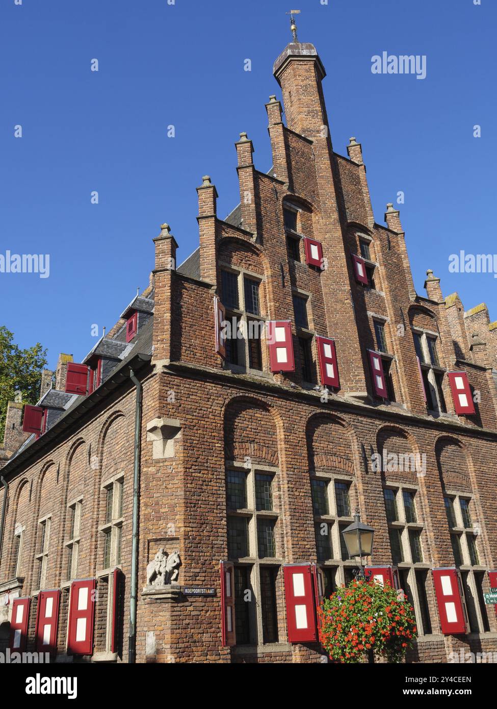 Historic brick building with red shutters under a clear blue sky ...