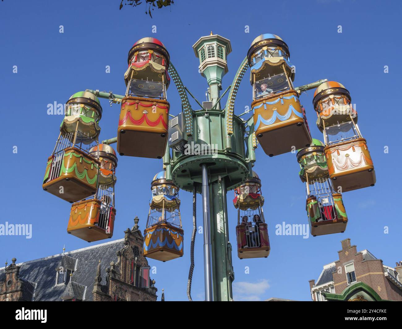 Colourful carousel cabins in an amusement park in front of historic ...