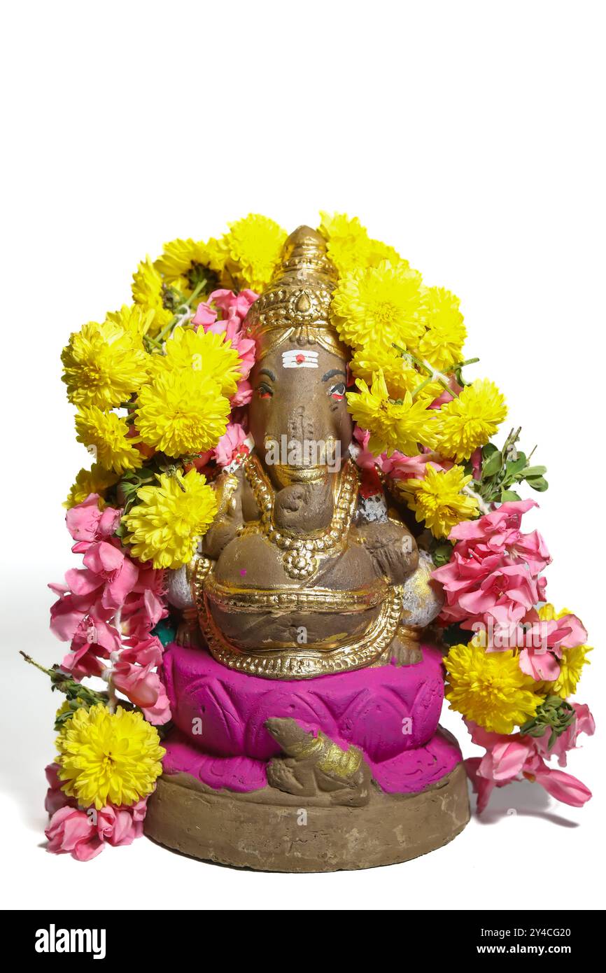 Hindu god Ganesha statue made of clay decorated with flower garlands on ...
