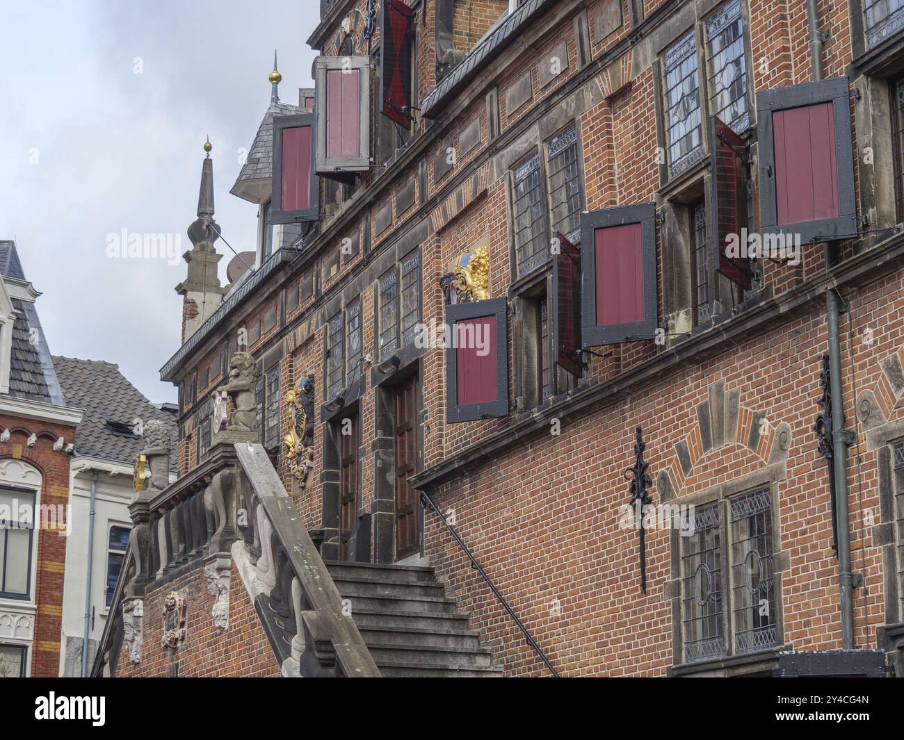 Historic building with red bricks and shutters, stairs on the side ...