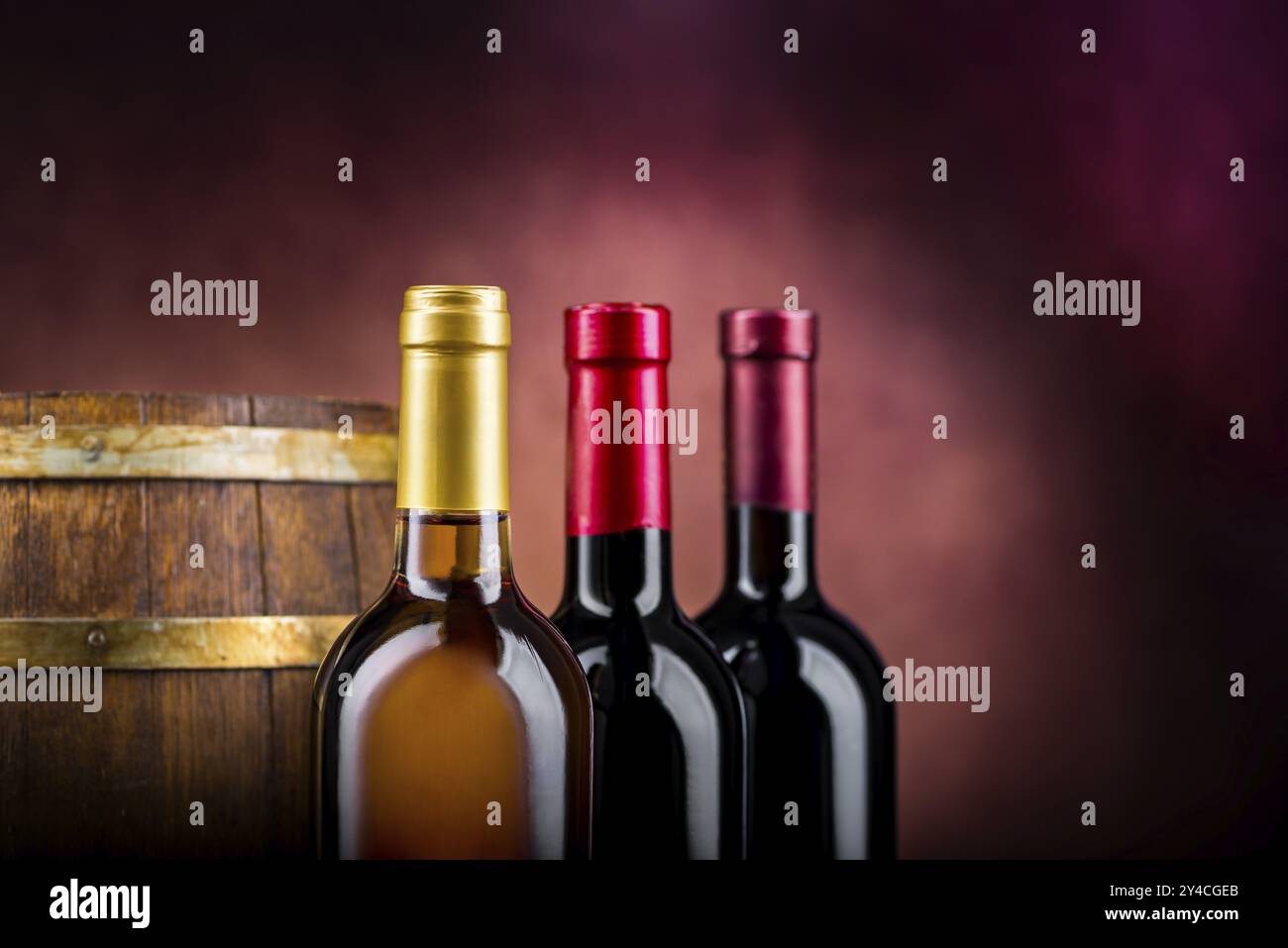 Three bottles of wine and wooden barrel on a burgundy background Stock ...