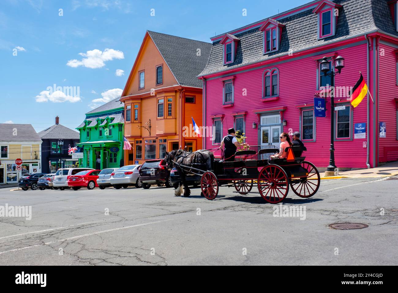 Colourful historical houses, tourists sightseeing on a horse drawn ...