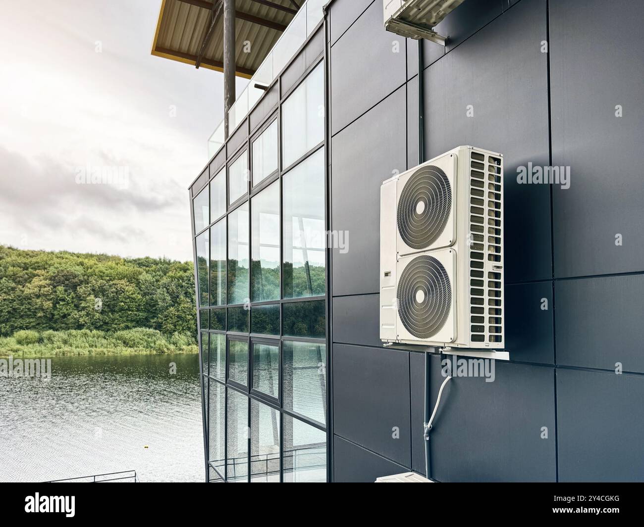 Outdoor cooling units attached to modern building with glass windows ...