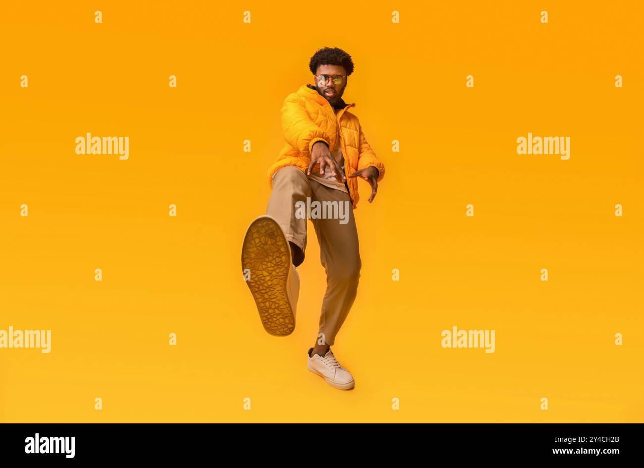 Black funny guy showing beast, stepping on camera Stock Photo - Alamy