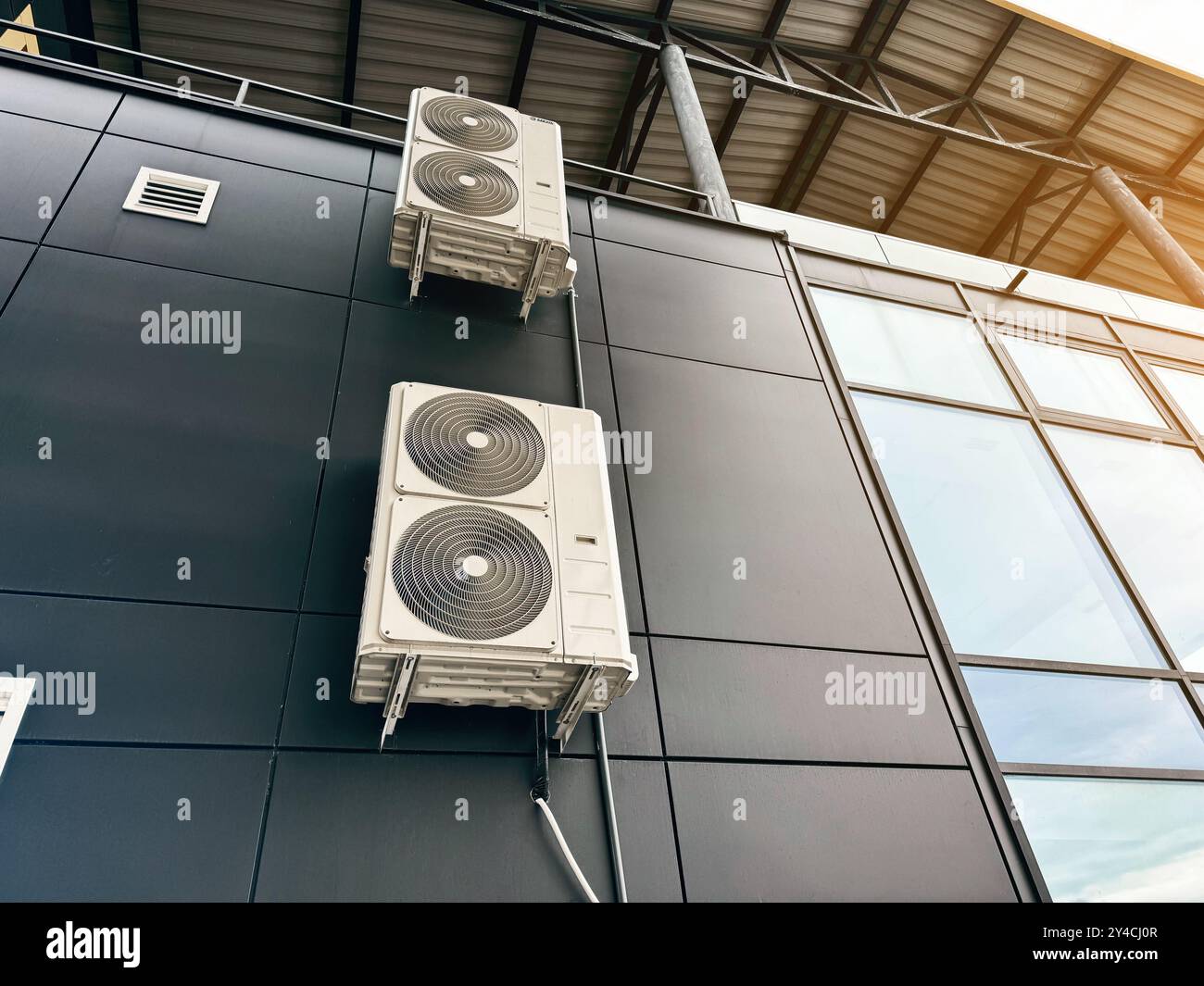 Commercial HVAC system installed on building exterior with glass, steel ...