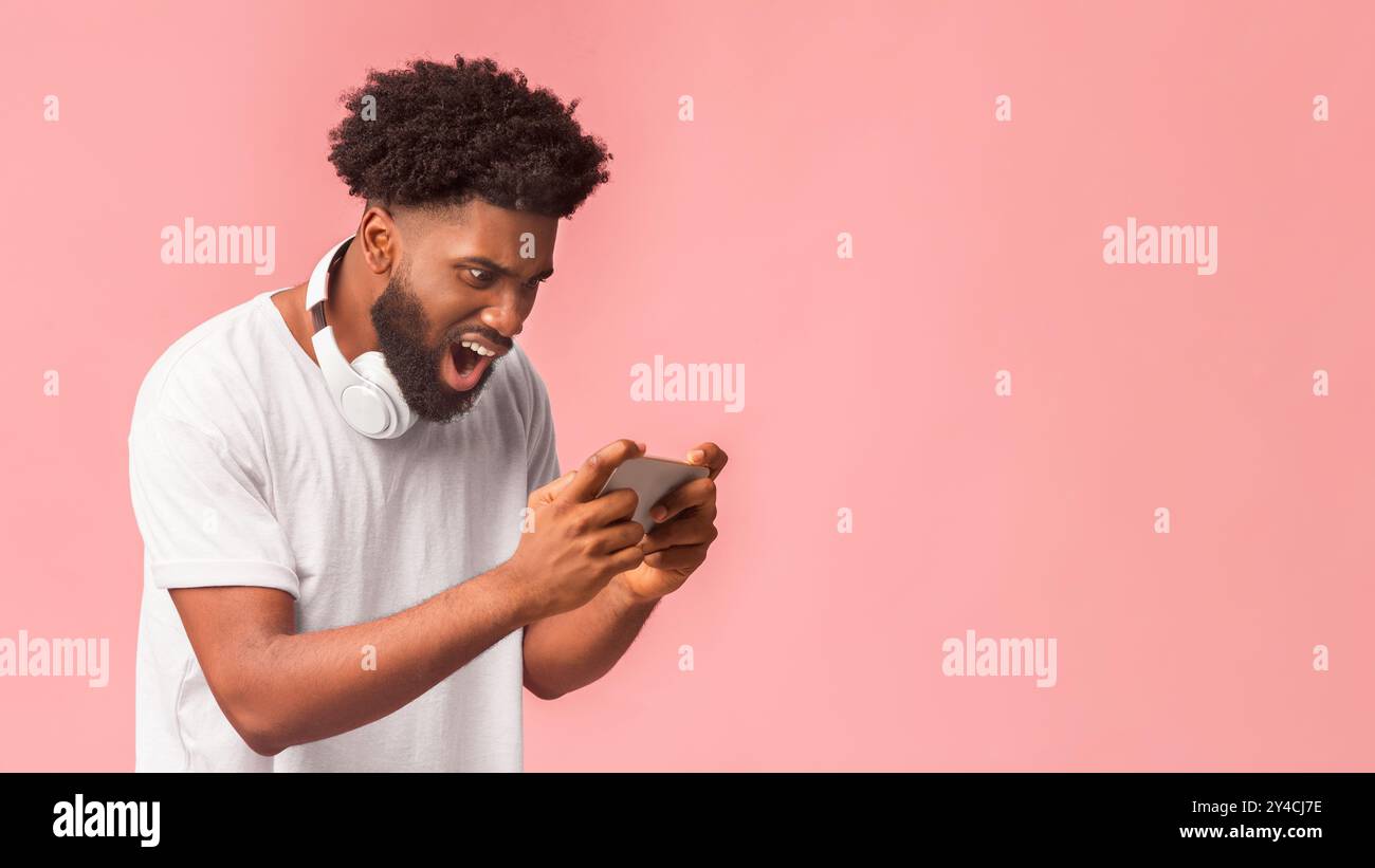 Anxious man looking at phone with angry face Stock Photo - Alamy