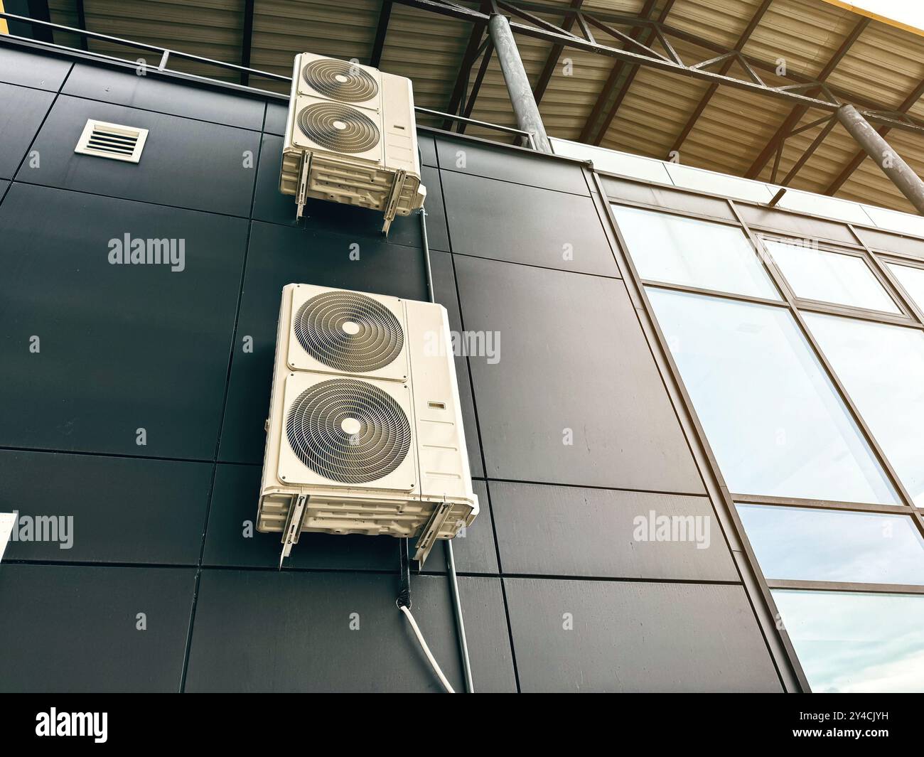 Industrial air conditioning units mounted on a modern glass and steel ...