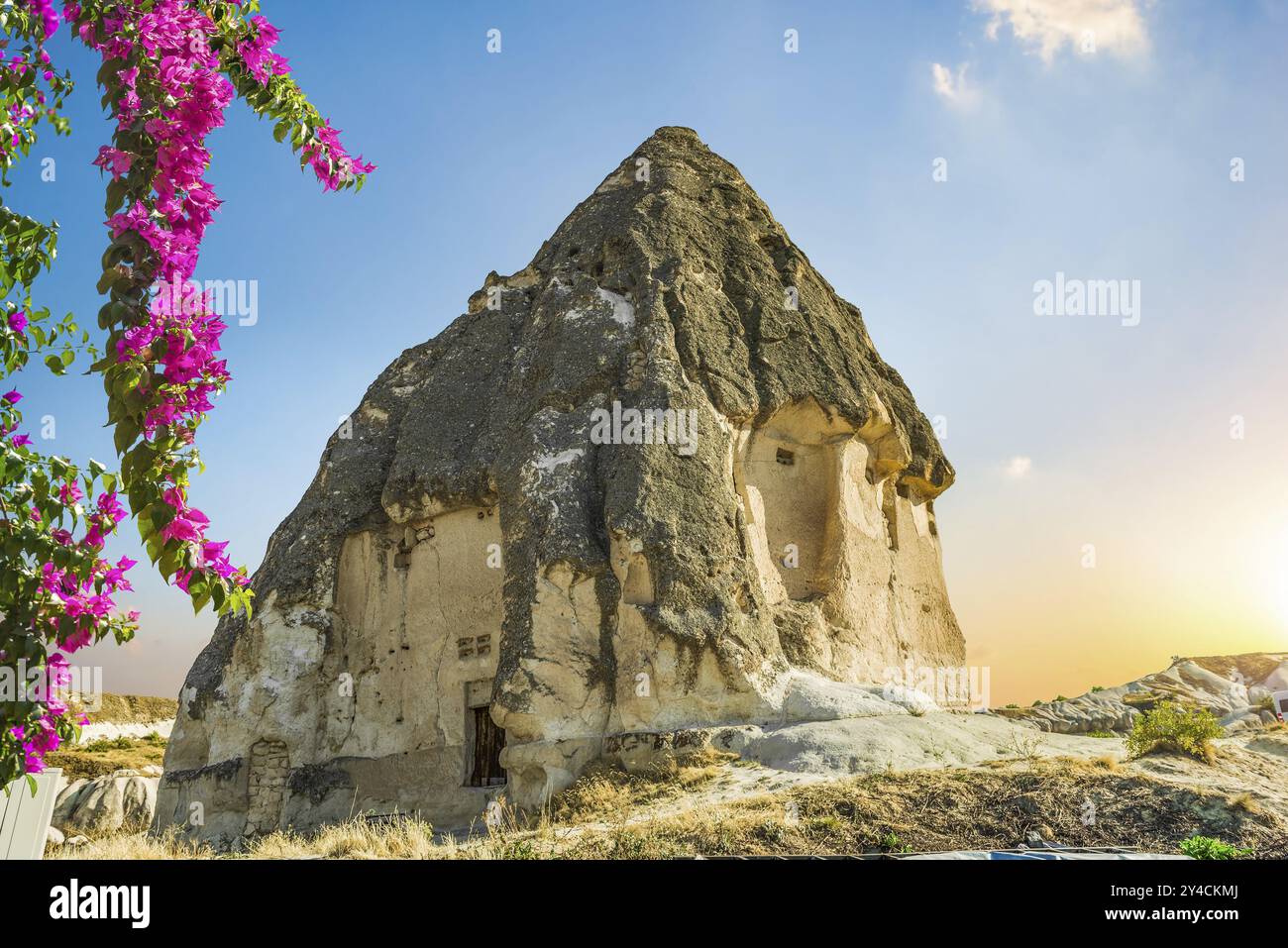 Old sandstone cave and flowers in Cappadocia, Turkey, Asia Stock Photo ...