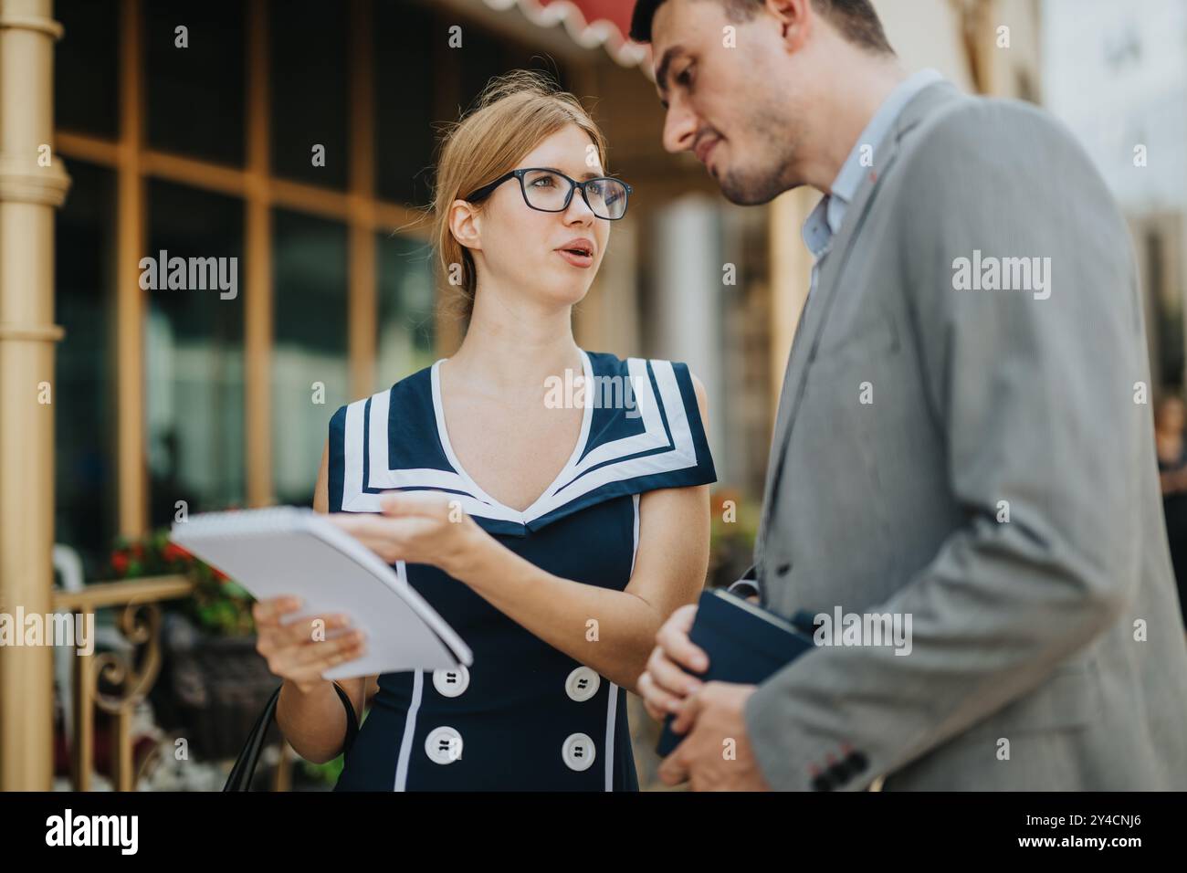 Professional conversation between two colleagues outside an office ...