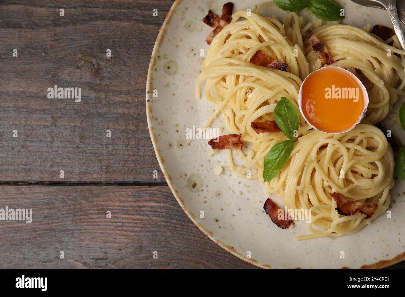 Delicious pasta Carbonara served on wooden table, top view. Space for ...