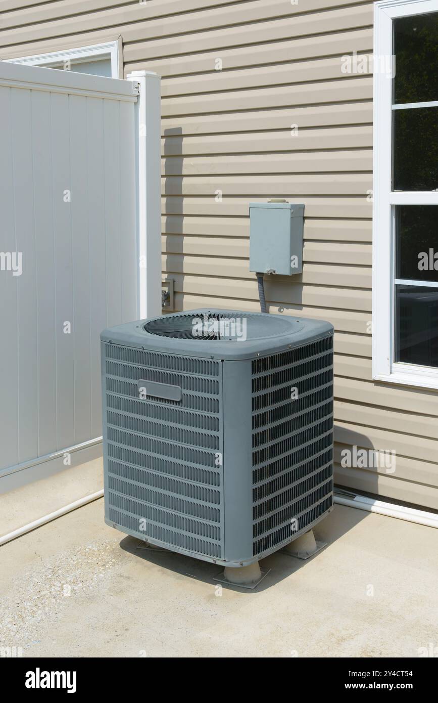 Vertical shot of an air conditioning unit sitting on the patio of a ...