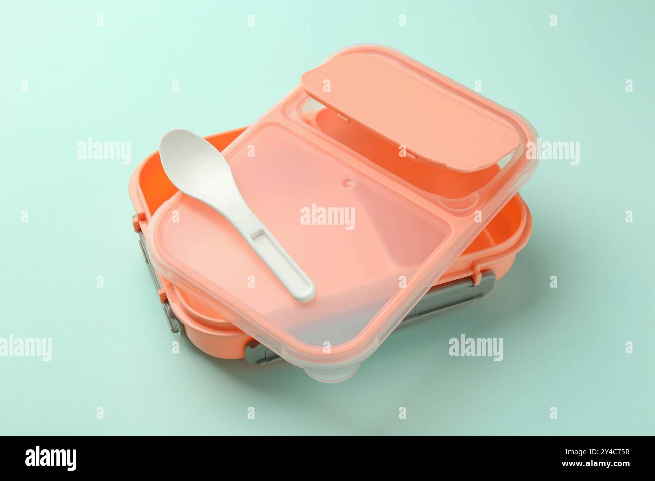 Empty lunch box with spoon on light blue background Stock Photo - Alamy