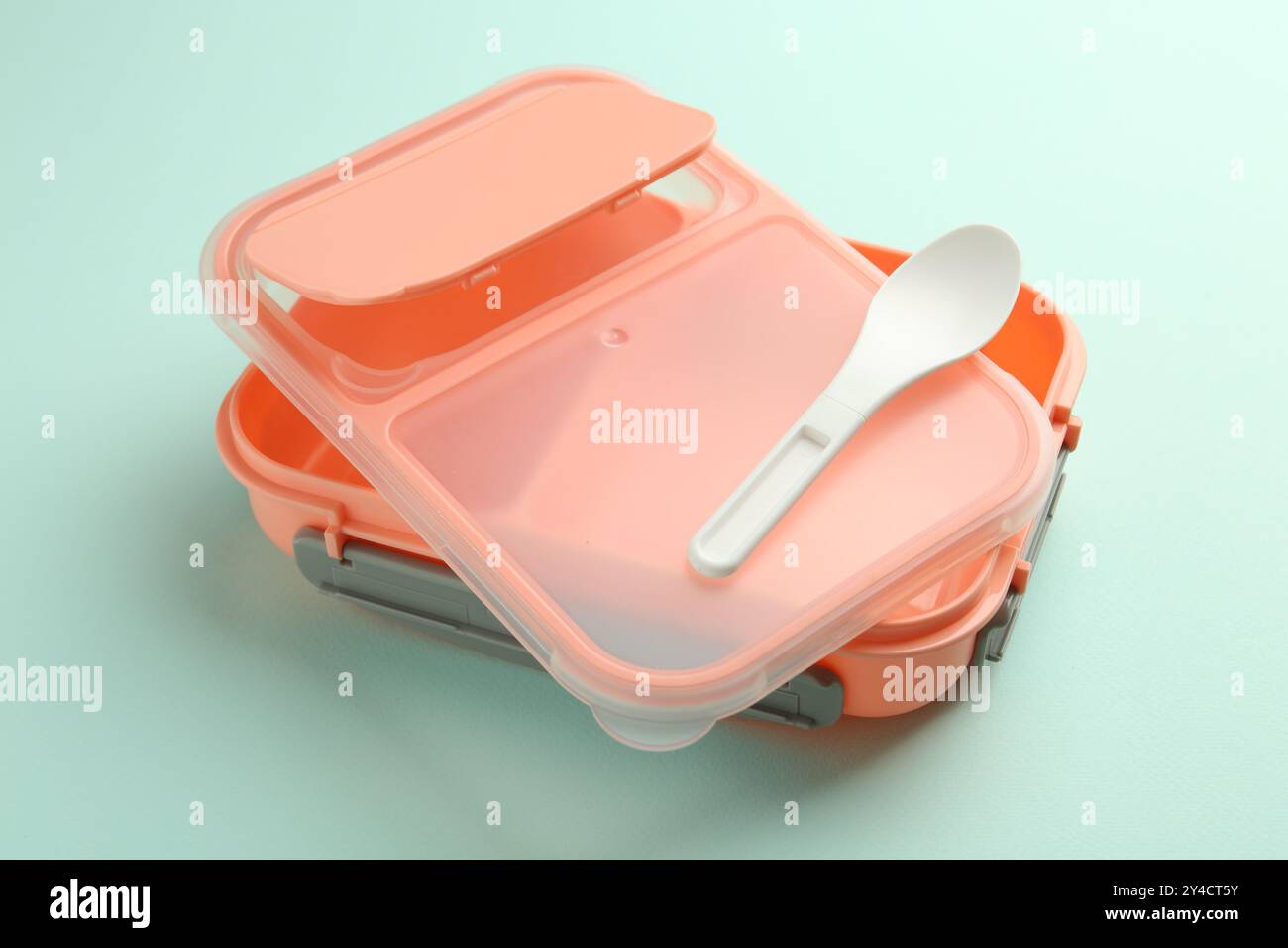 Empty lunch box with spoon on light blue background Stock Photo - Alamy