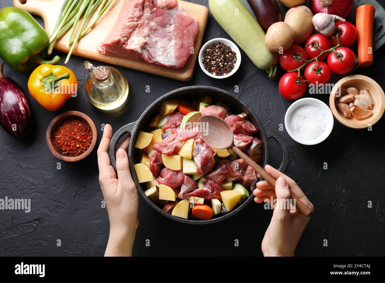 Cooking stew. Woman with uncooked meat, vegetables and pot on black ...