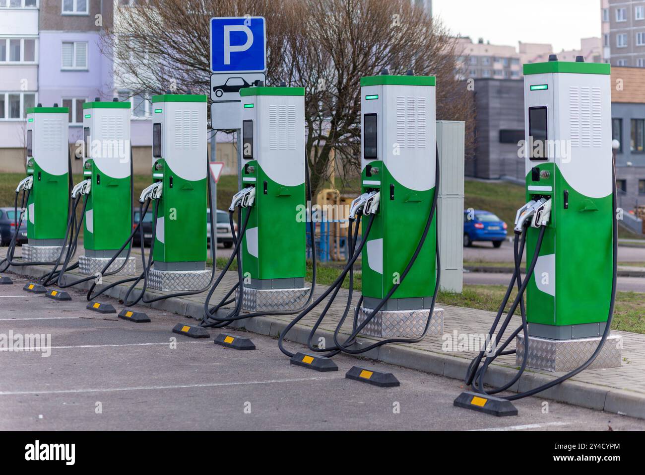 Several electric vehicle charging stations are lined up in a parking ...