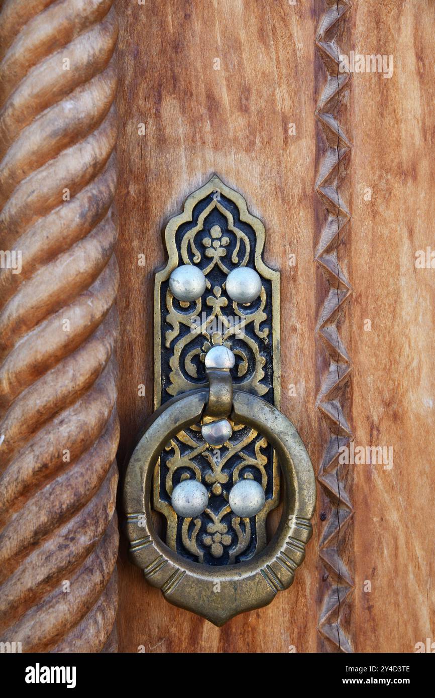 Massive brass handle on ancient carved wooden door. Hometown of ...