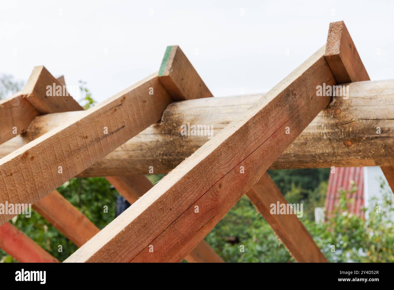 Wooden house roof is under construction. Background photo with rafters ...