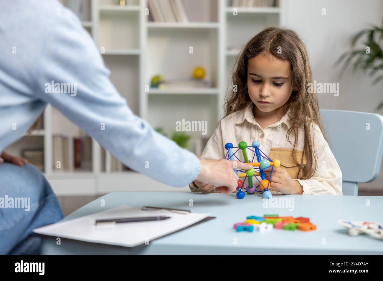 Cute long-haired girl looking busy while having a tutorial with a ...