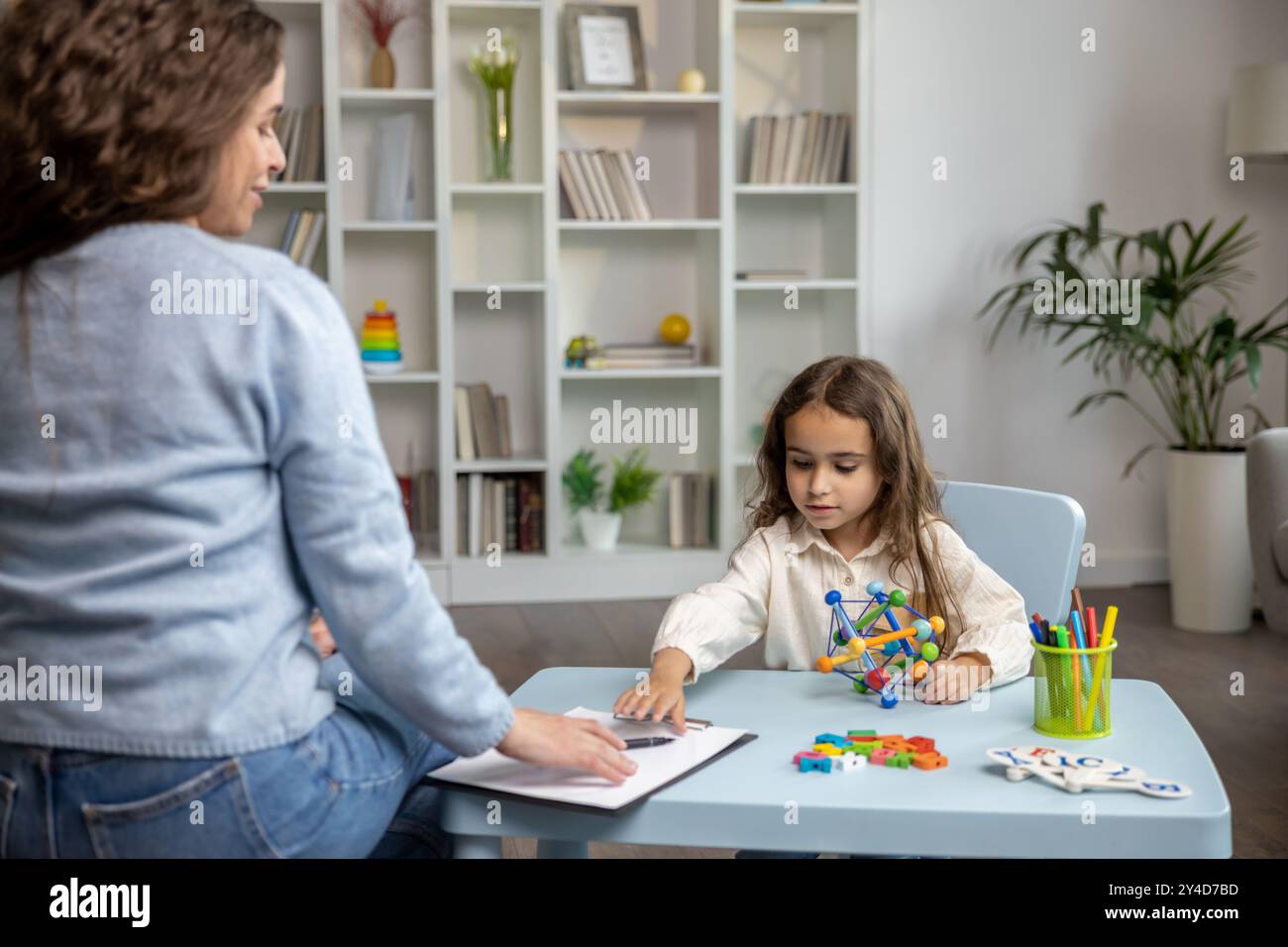 Cute long-haired girl looking busy while having a tutorial with a ...