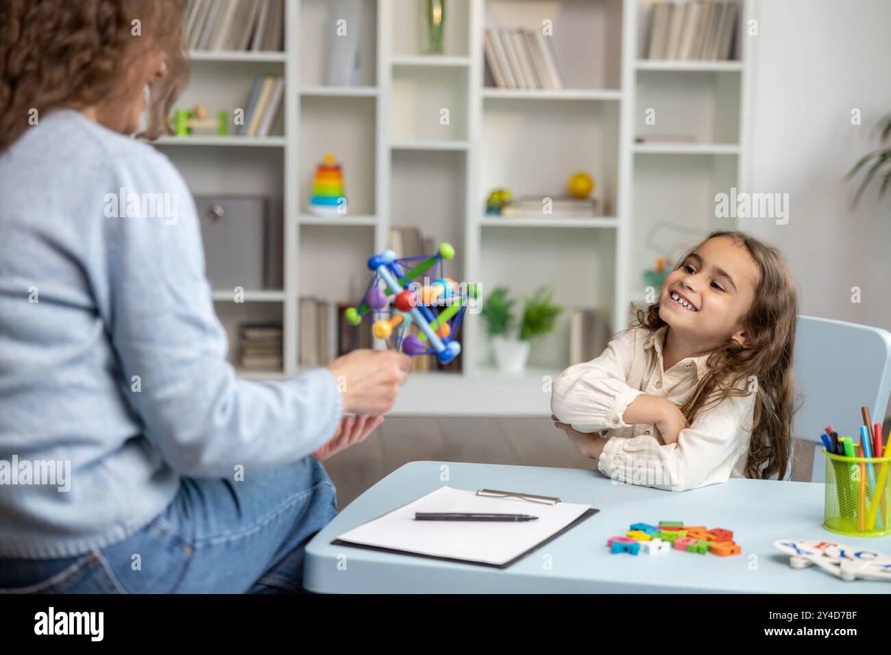 Cute long-haired girl looking busy while having a tutorial with a ...