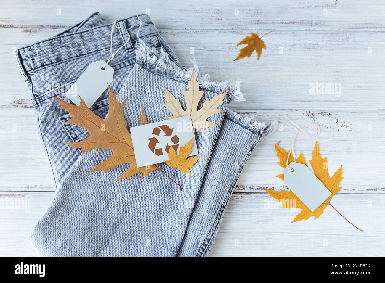 Denim jeans with empty paper tag and Recycling symbol Stock Photo - Alamy