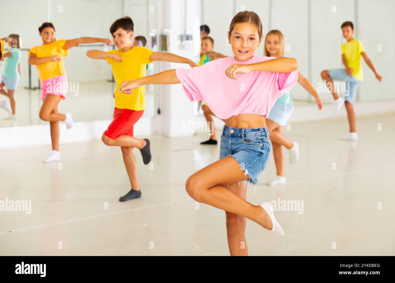 Happy tween girl dancing during group class in choreographic studio ...