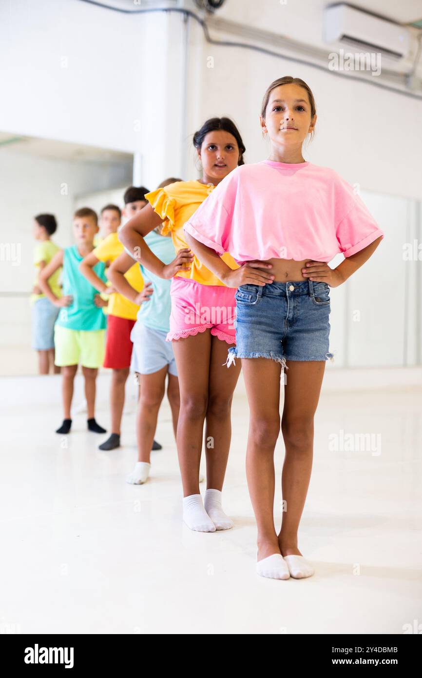 Tween girl with children standing in row one by one in choreography ...