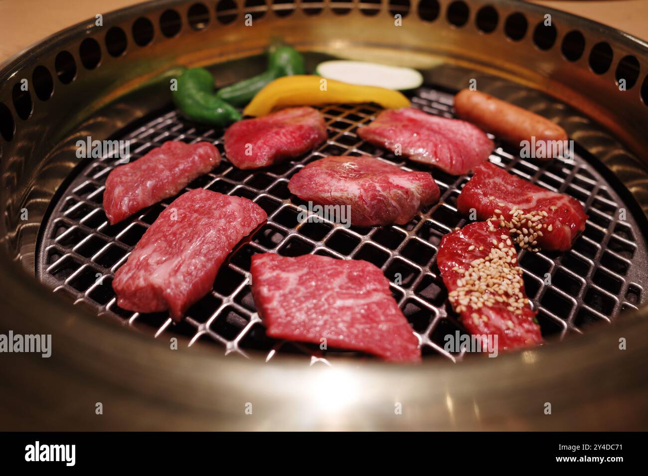 A close-up shot of premium Wagyu beef slices grilling on a traditional ...