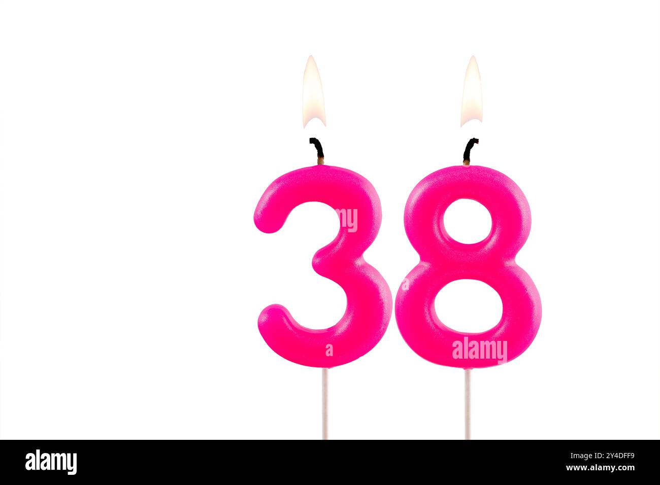 Pink number 38 birthday candle lit on white background Stock Photo - Alamy