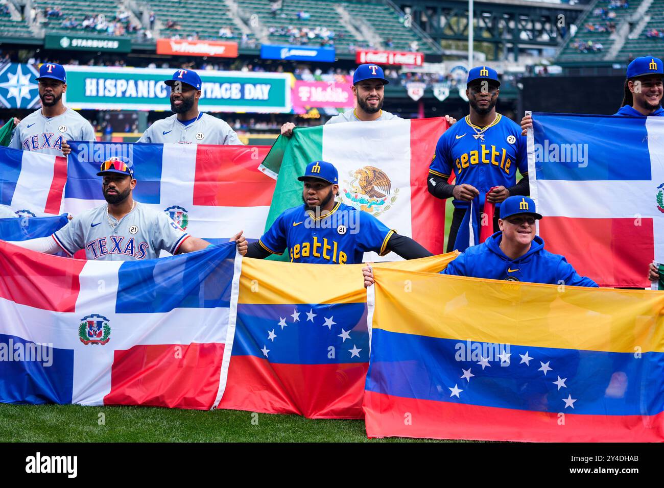 Texas Rangers and Seattle Mariners players pose with their country flags for Hispanic Heritage ...