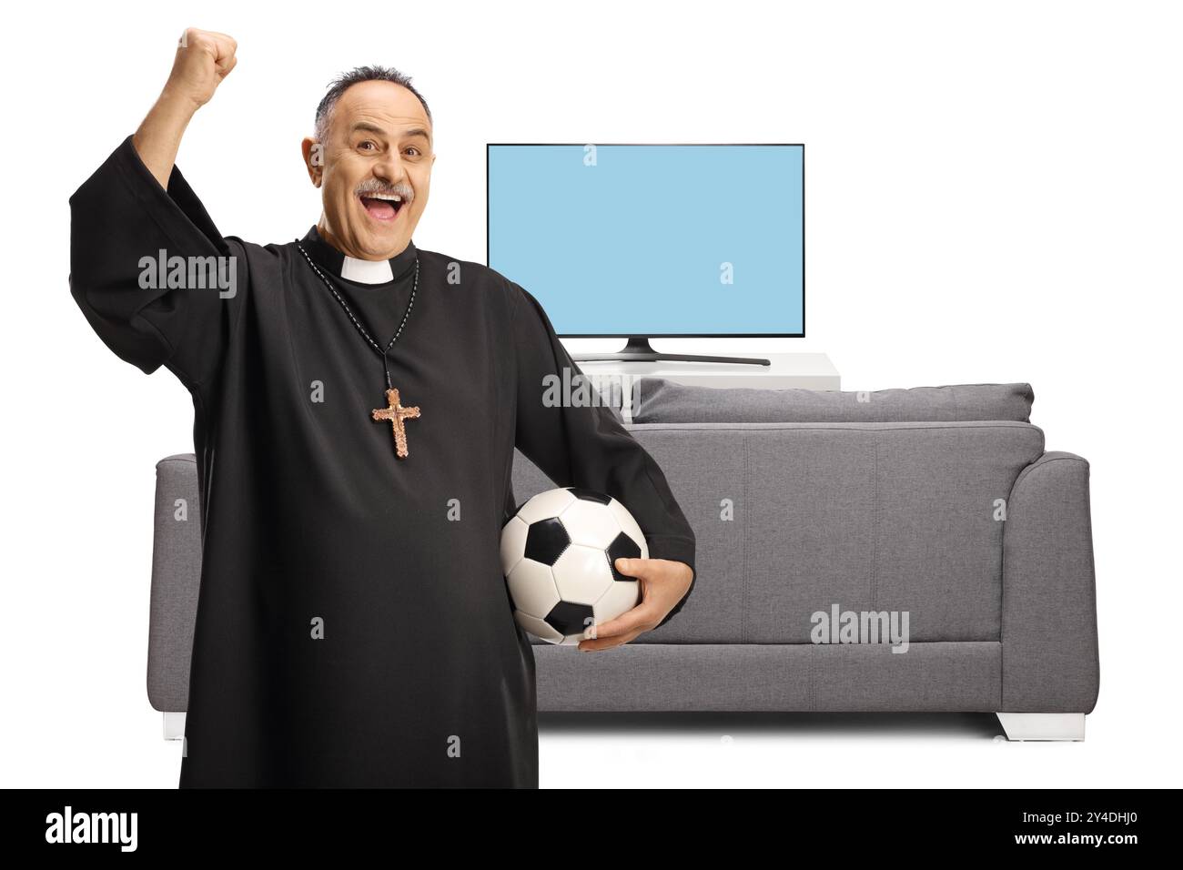 Happy priest holding a football and cheering in front of tv isolated on ...