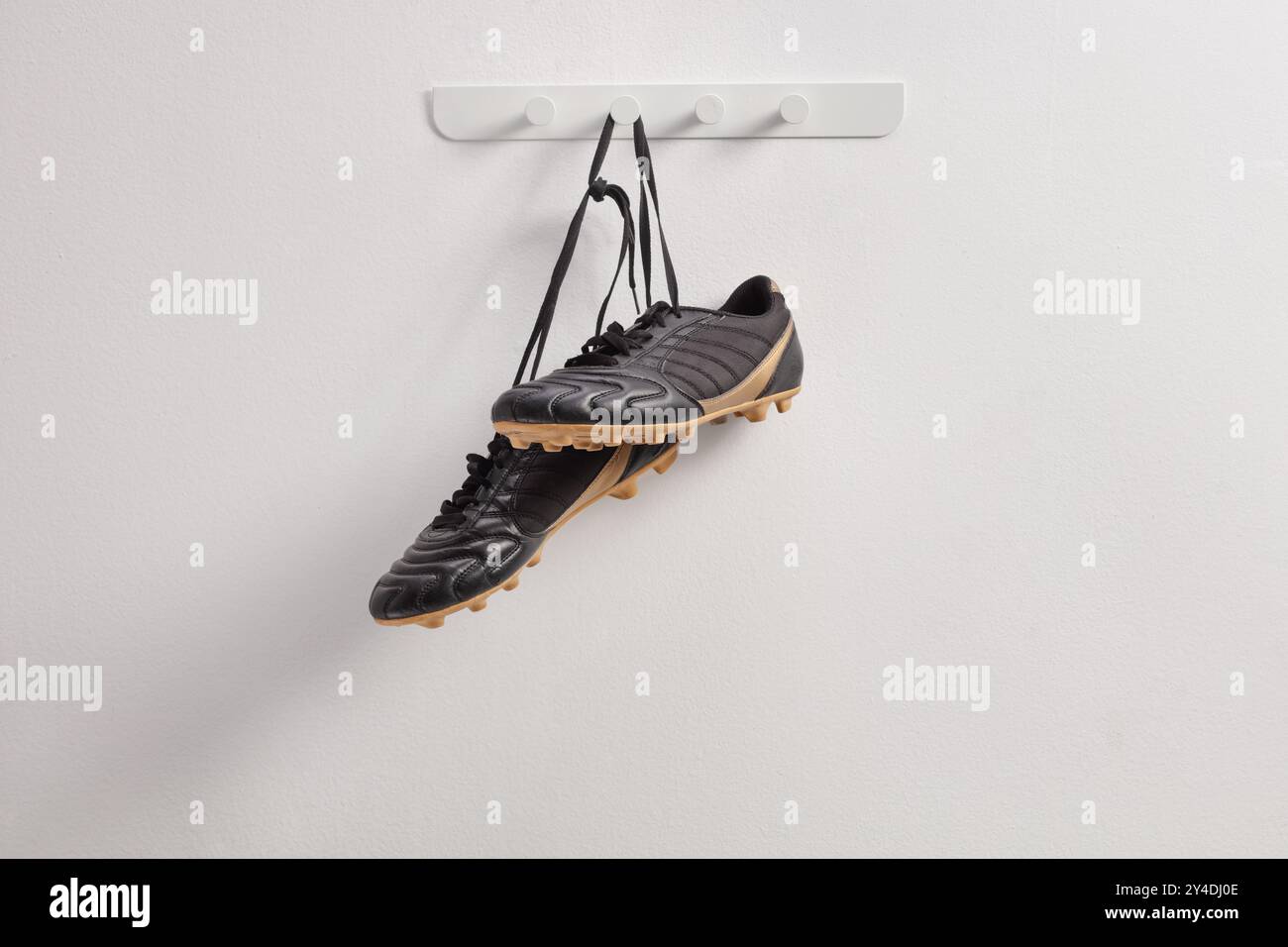 Black football cleats hanging on a wall Stock Photo - Alamy