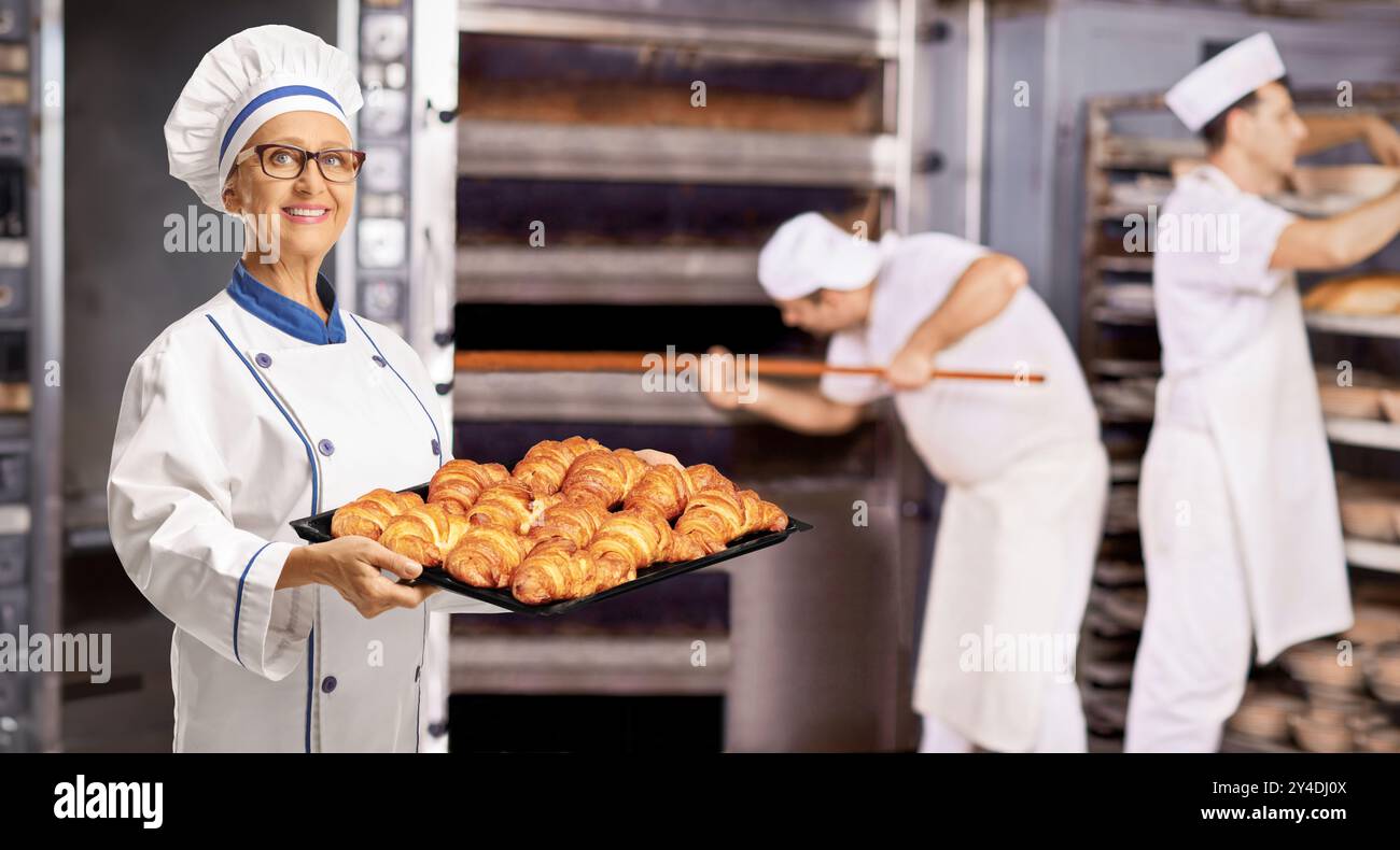 Female chef holding a tray with croissants in a bakery Stock Photo - Alamy