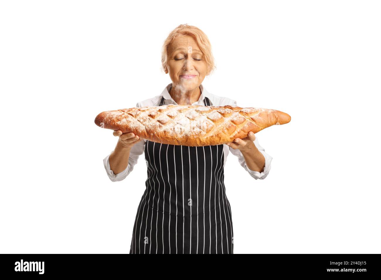 Woman wearing an apron and smelling a homemade bread isolated on white ...