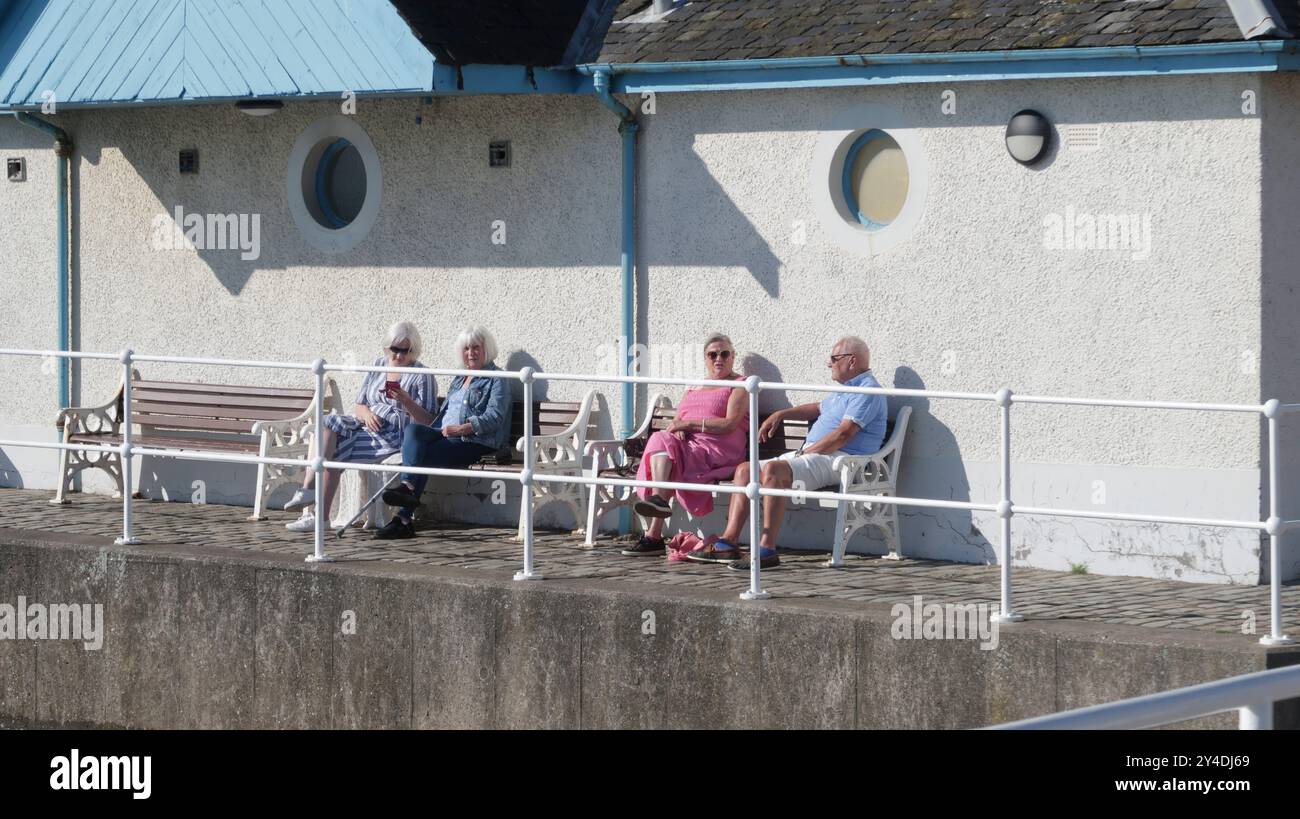 Elderly people relaxing in the sun by Anstruther Harbour Stock Photo ...