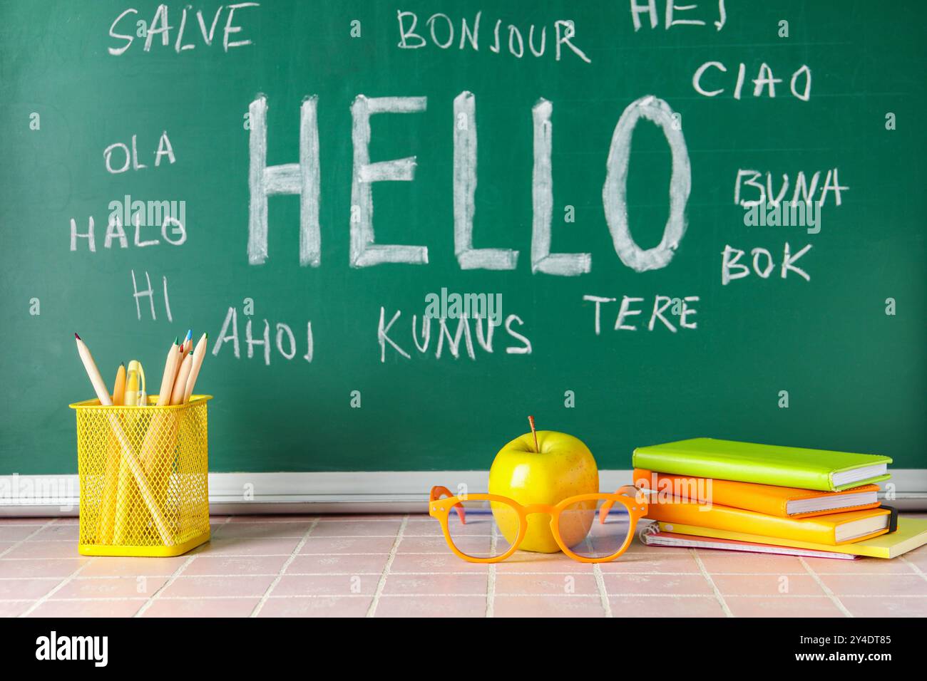 Blackboard with word HELLO in different languages and stationery on ...