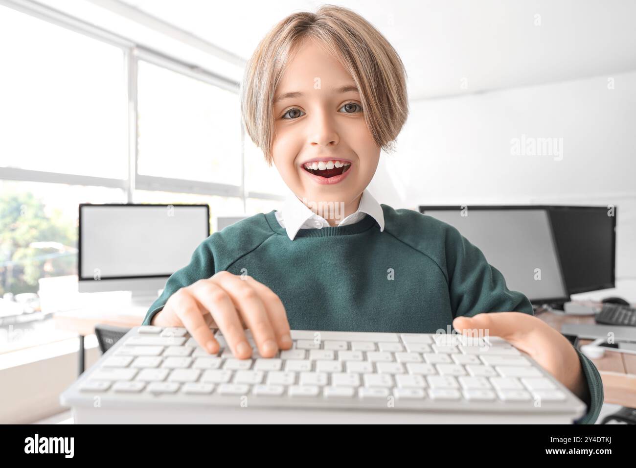 Little boy with keyboard at school computer lab Stock Photo - Alamy
