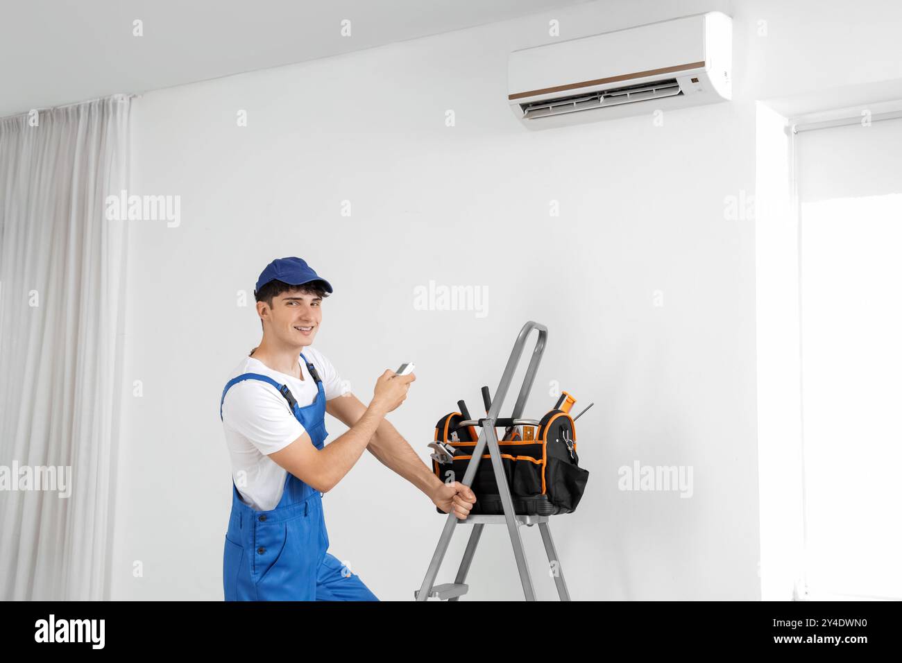 Male worker repairing air conditioner in room Stock Photo - Alamy