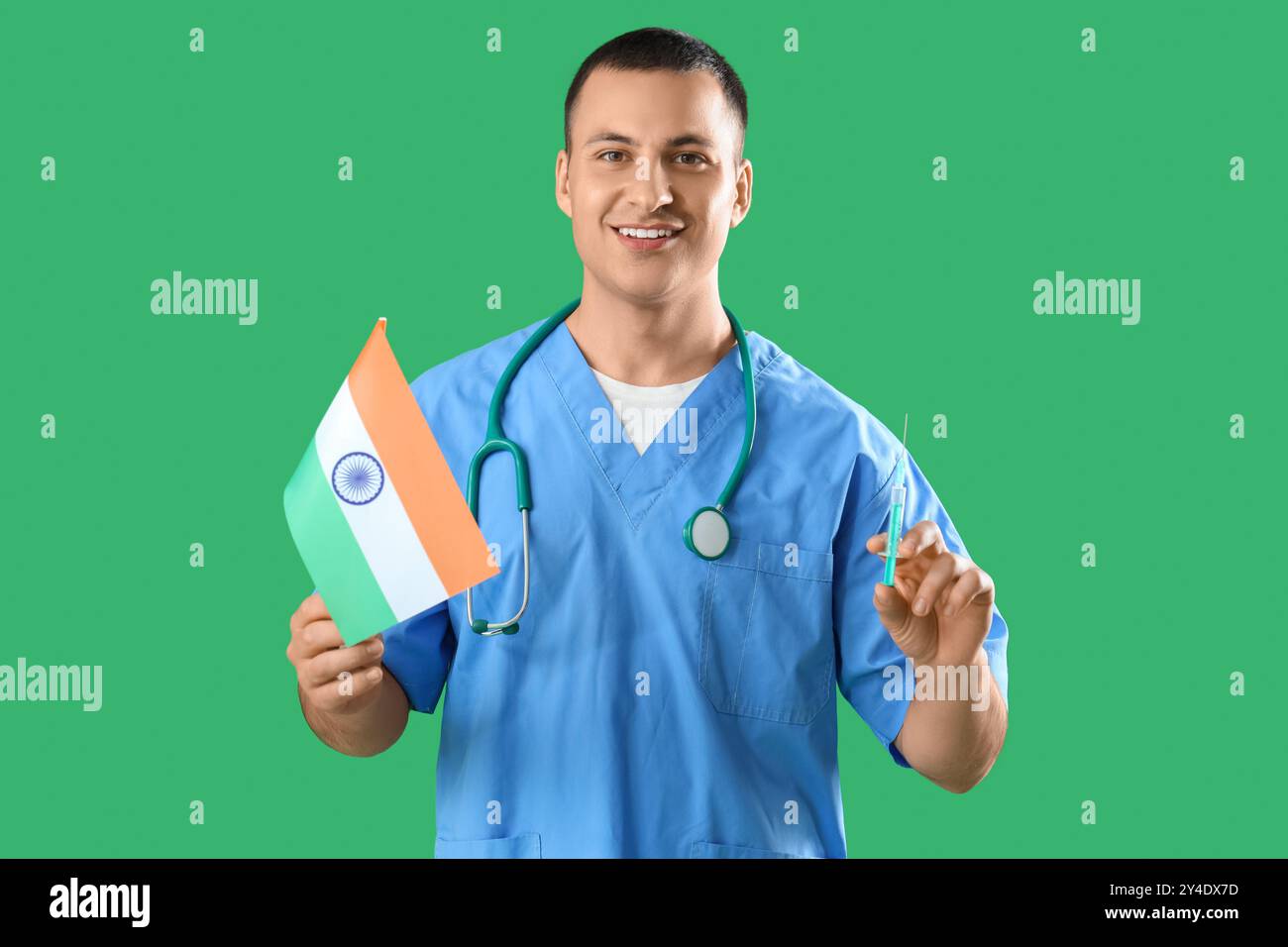 Male doctor with flag of India and syringe on green background ...