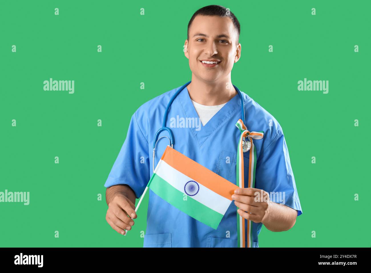 Male doctor with flag of India and ribbon on green background. National ...