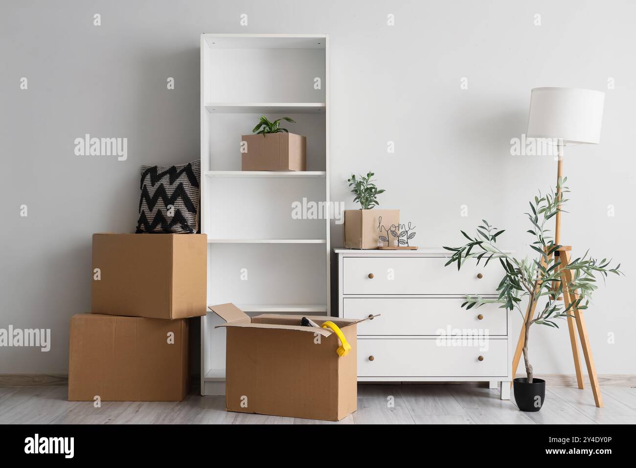 Cardboard boxes with shelf unit and drawers near light wall in room ...