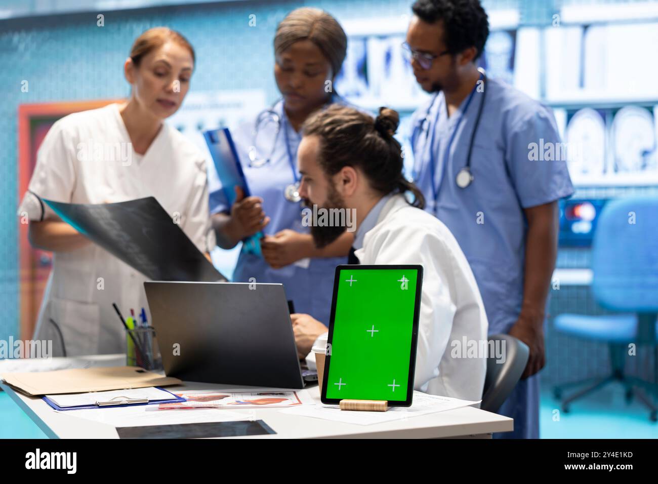 Team of doctors consulting analytics next to green screen on laptop in ...