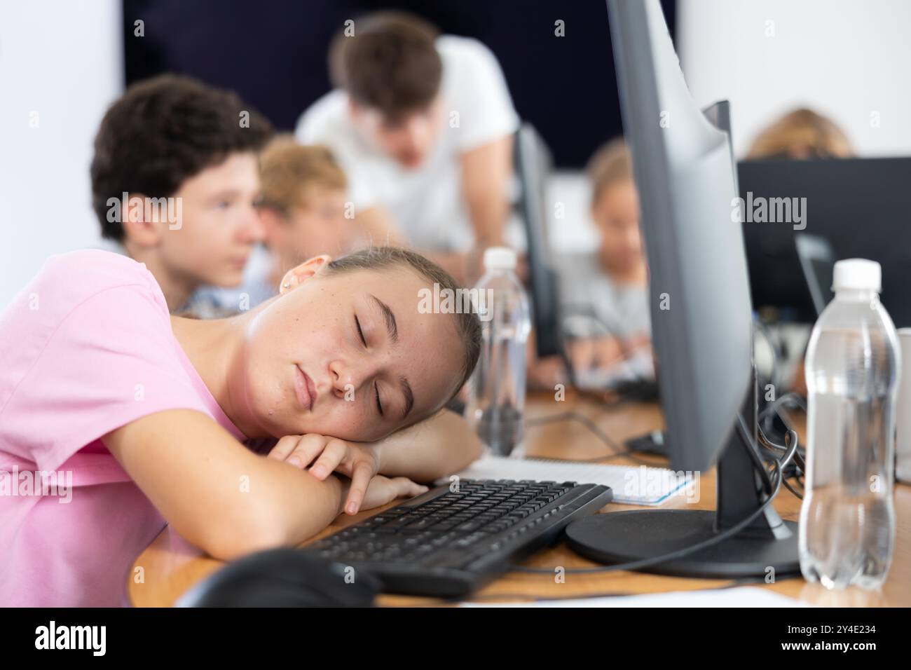 Tired girl fell asleep on computer keyboard in school class Stock Photo ...