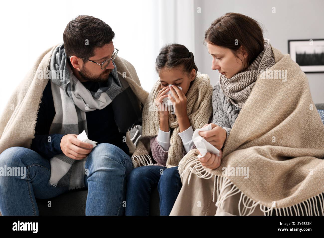 Cold symptom. Family suffering from fever on sofa at home Stock Photo ...