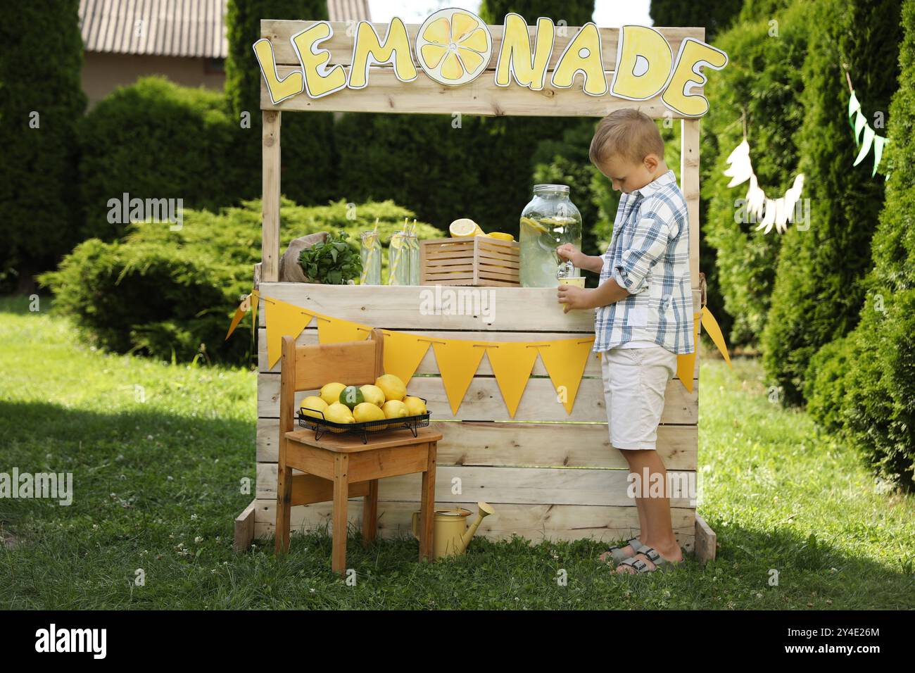 Cute boy pouring refreshing lemonade into paper cup in park Stock Photo ...