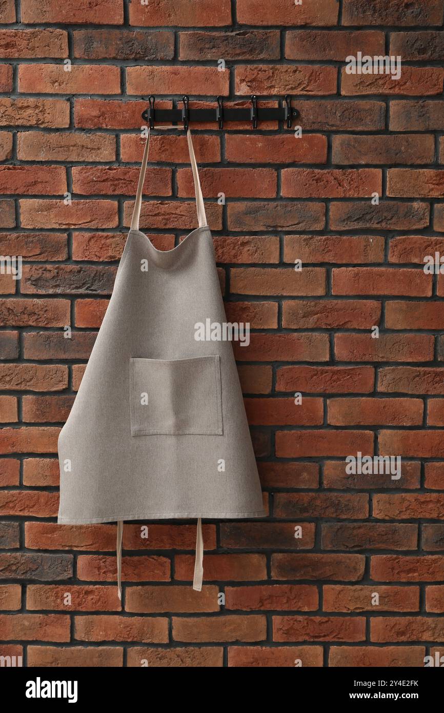 One chef's apron hanging on brick wall Stock Photo - Alamy