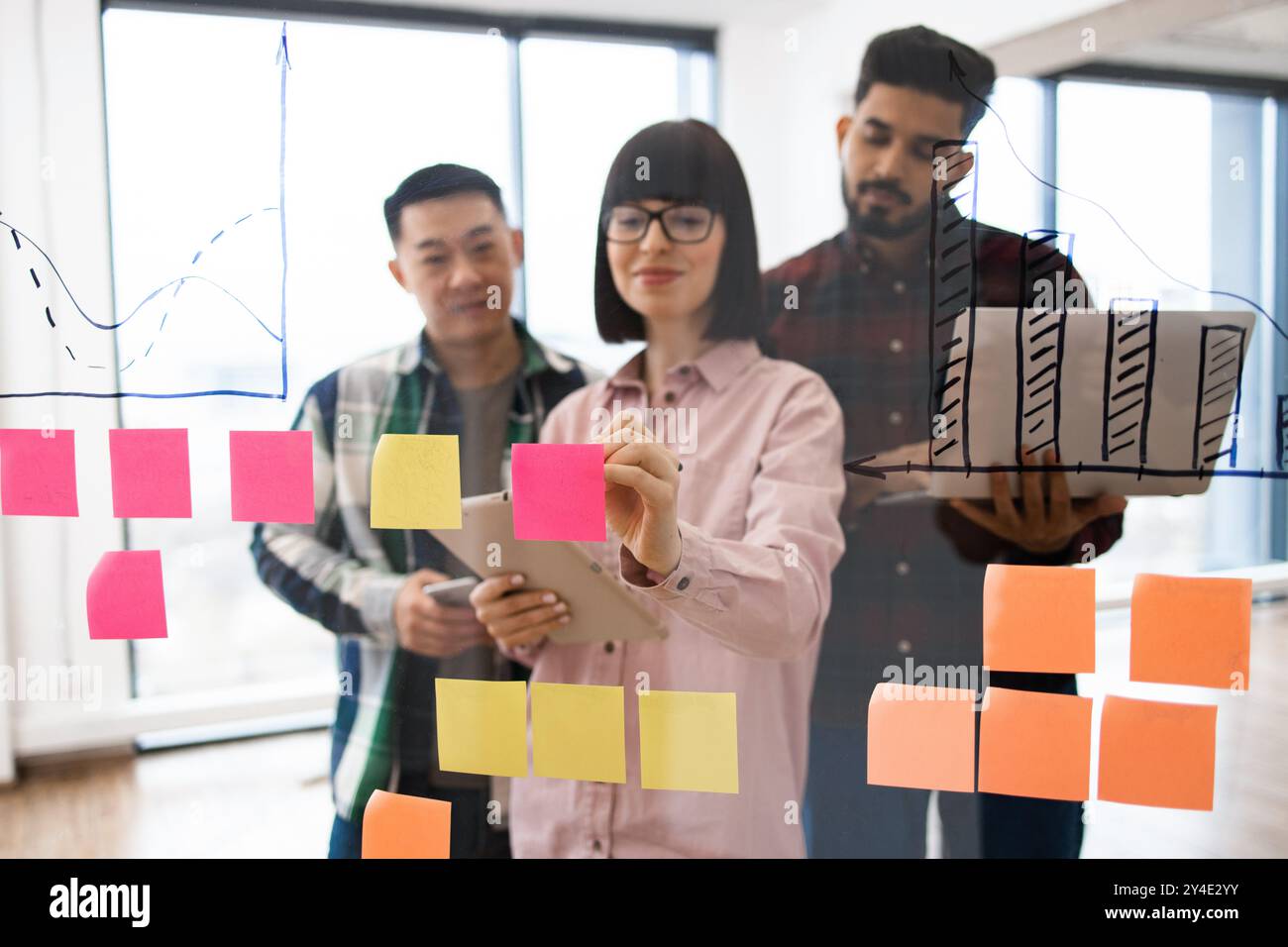 Team brainstorming session using post-it notes and charts Stock Photo ...