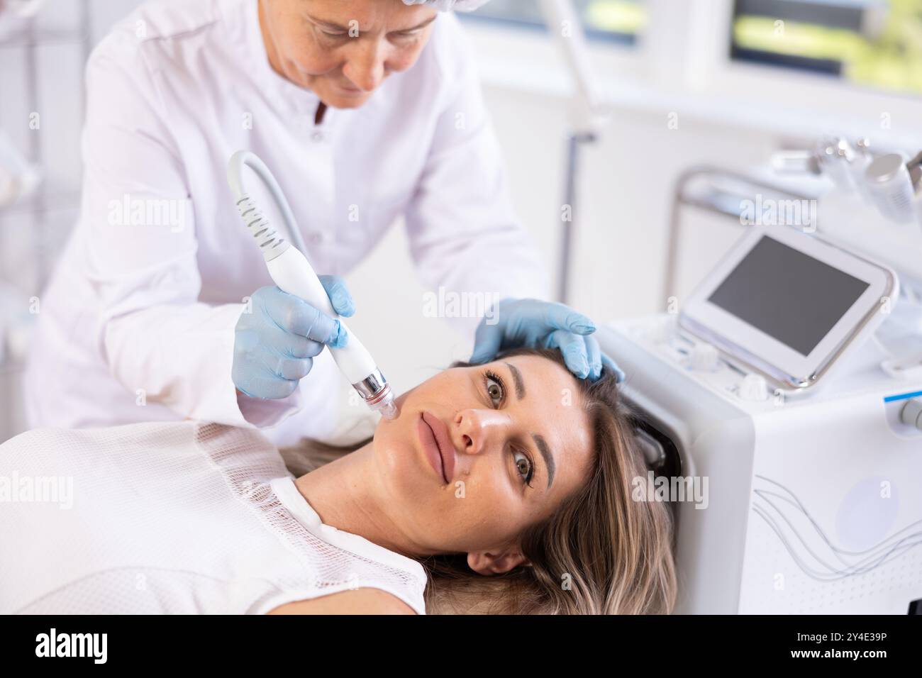 Blonde woman getting facial deep hydration procedure from experienced ...