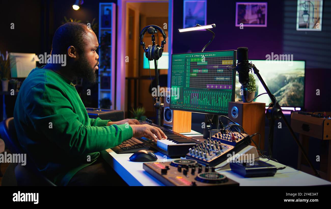 Producer composing new track with electronic gear in his home studio ...