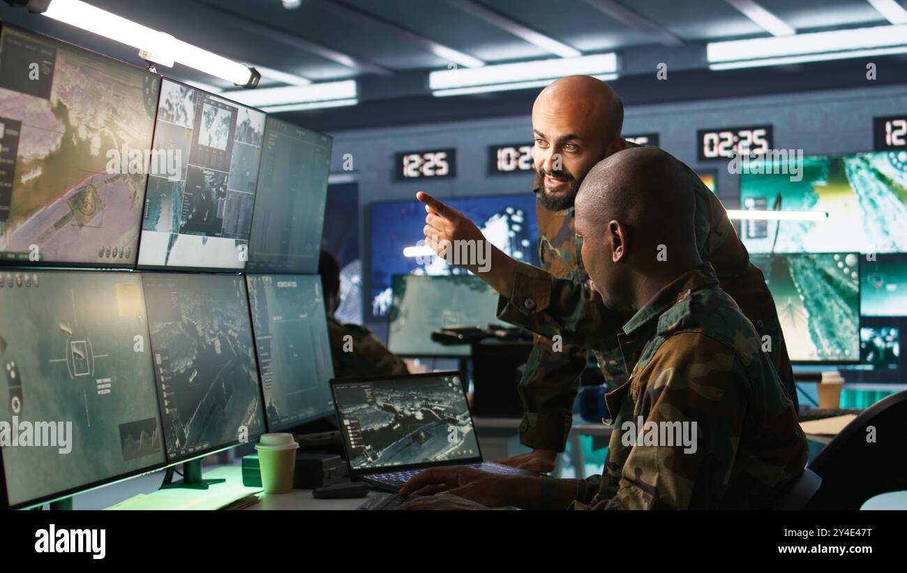 Army colleagues looking at screens in command center housing ...